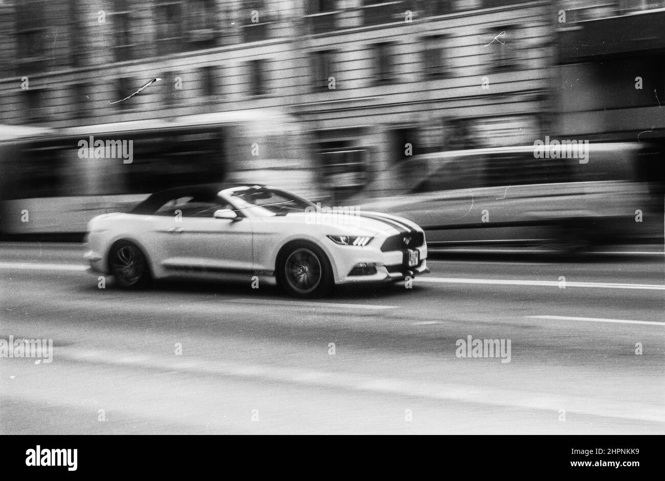Old classic and beautiful Ford Mustang quickly flies down the street ...