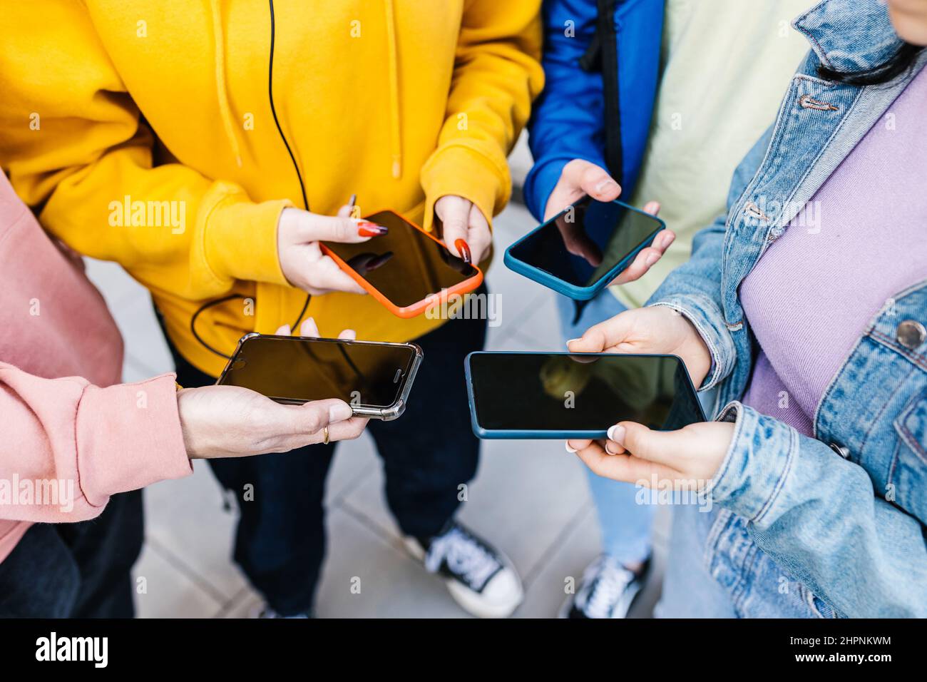 Group of teenager friends holding smartphone outdoors Stock Photo - Alamy
