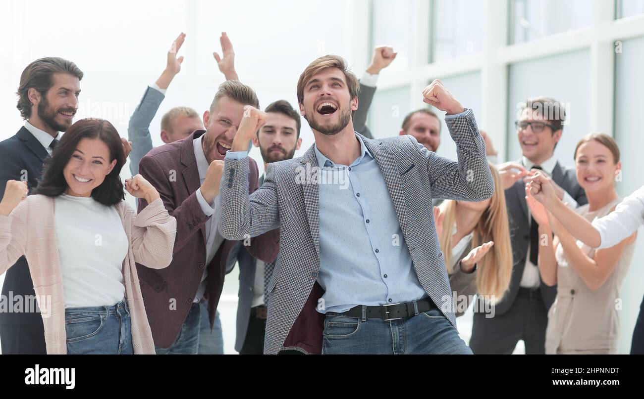 close up. cheerful employees congratulating a colleague on the ...