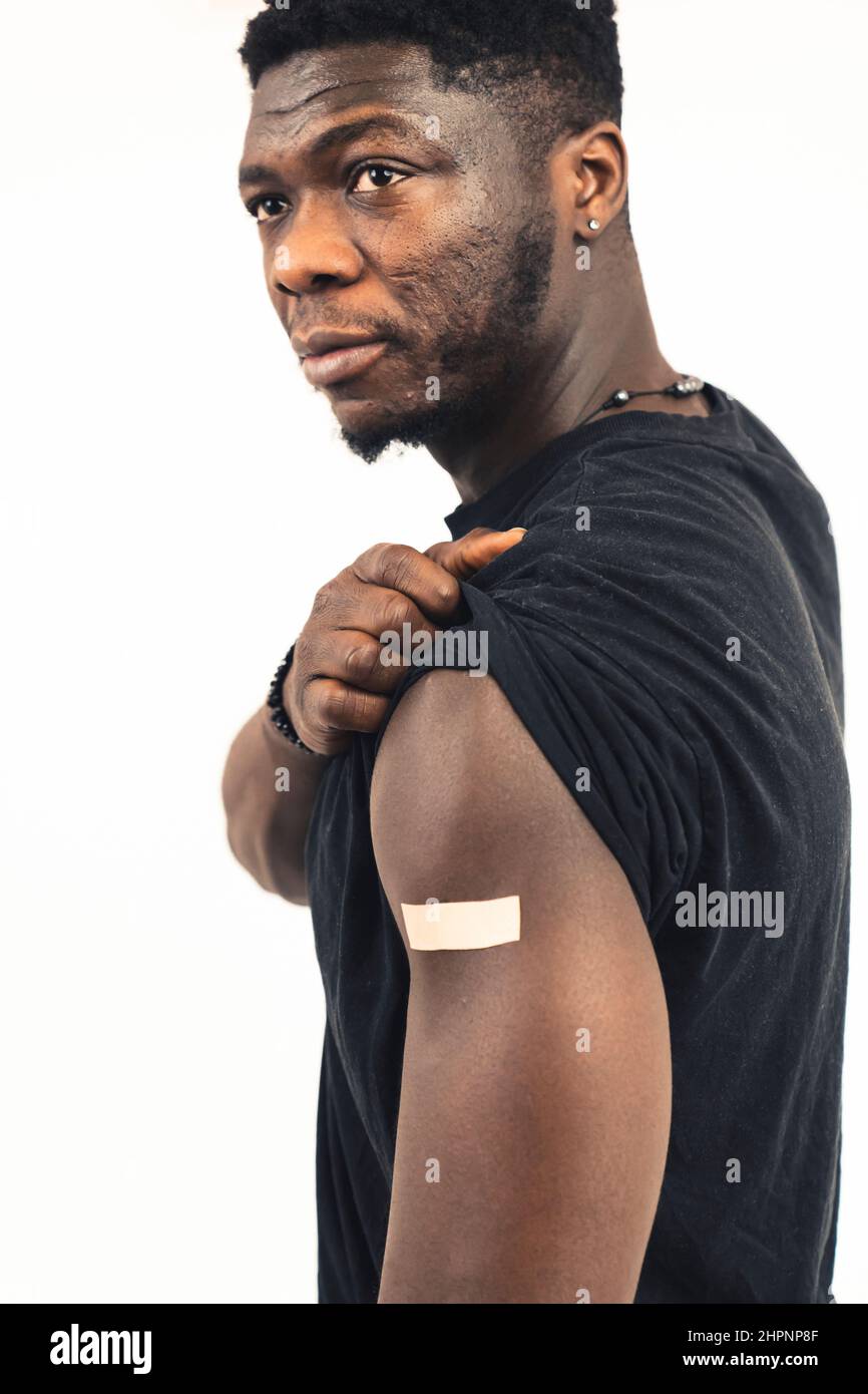 vaccinated black man showing arm white backround - portrait shot. High ...