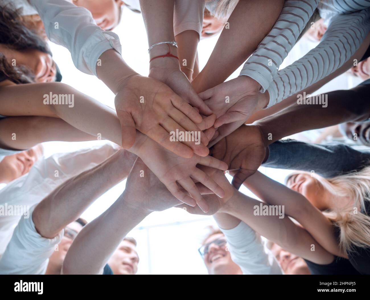 bottom view . group of young people joining their palms together . the ...