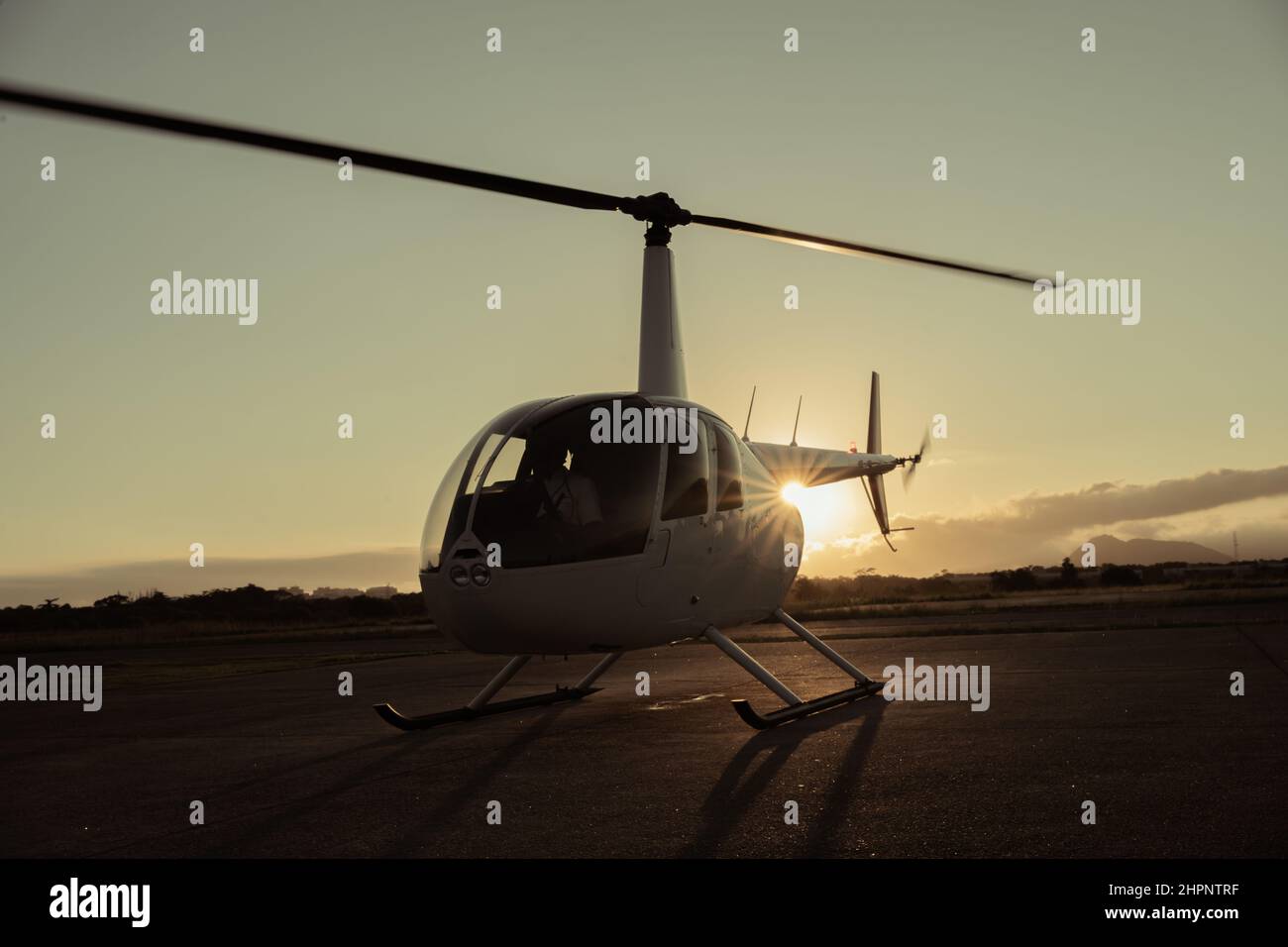 Helicopter on the runway at sunset Stock Photo - Alamy