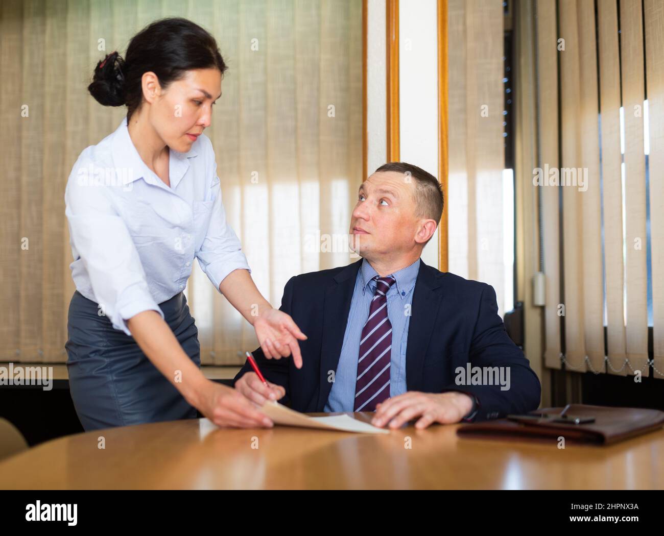 Business man and woman in office filling up documents Stock Photo - Alamy