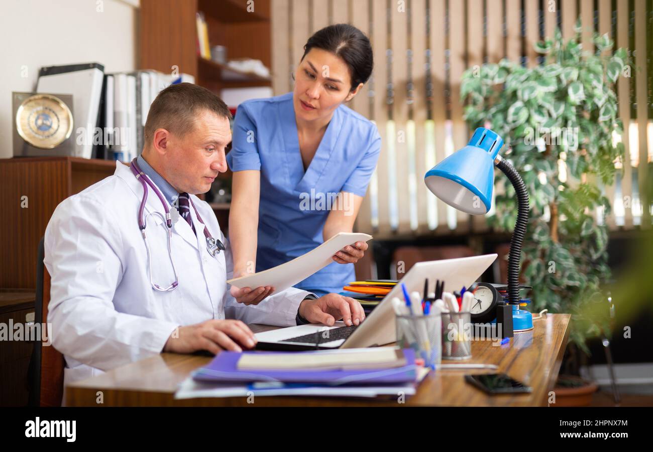 Two doctors checking patient papers in clinic Stock Photo - Alamy