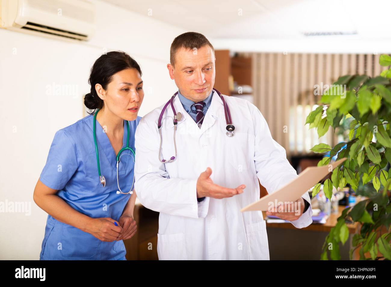 Two doctors checking patient papers in clinic Stock Photo - Alamy