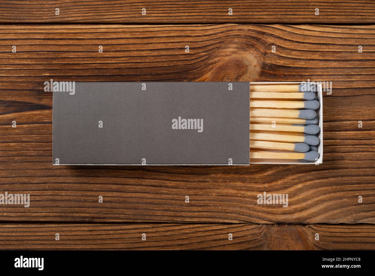 top view grey color matchbox with grey match sticks on a wood table ...
