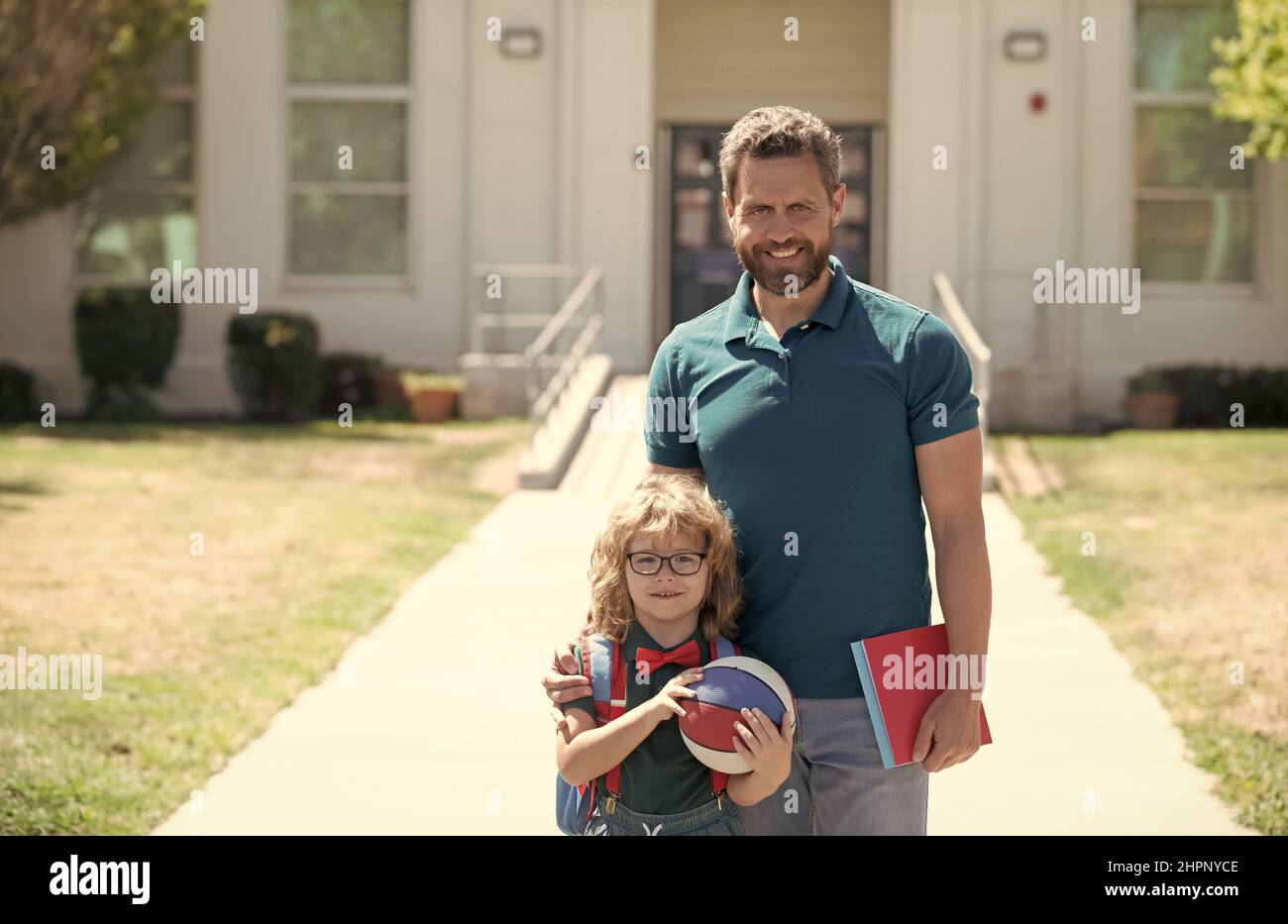 first day at school. father and son come back from school. happy family ...