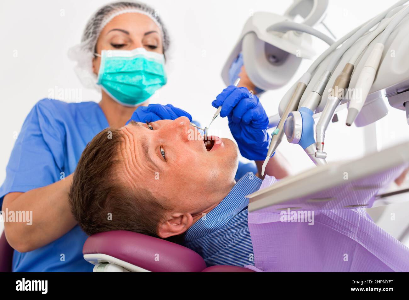 adult dentist checking teeth of patient male sitting in medical center ...