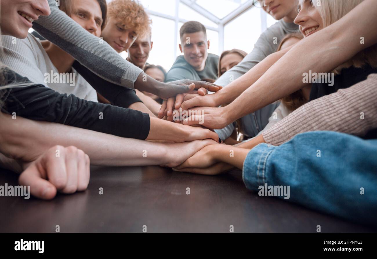 close up.a team of happy people joining their hands together. photo ...