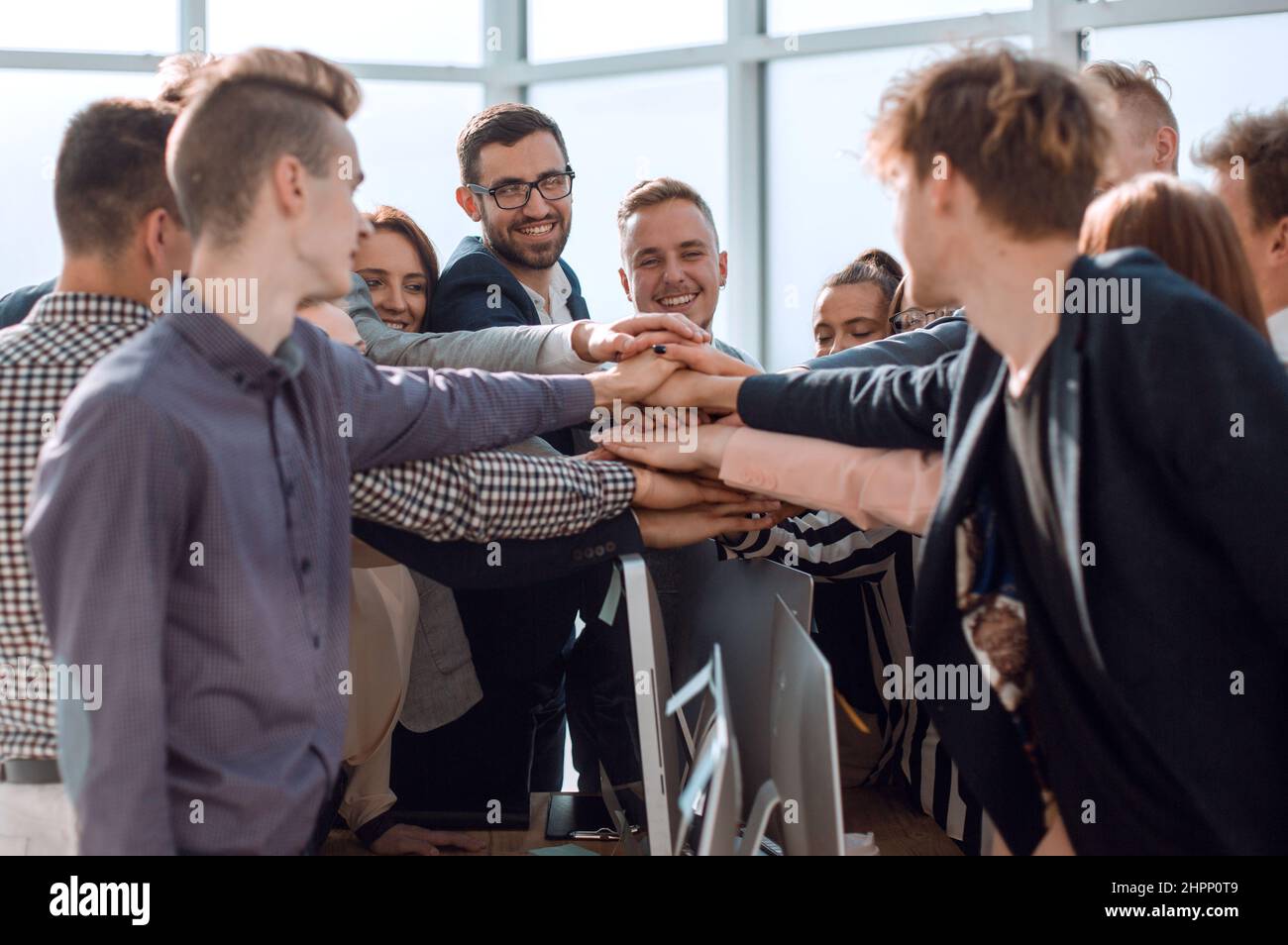 close up.agroup of young business people putting their palms together ...