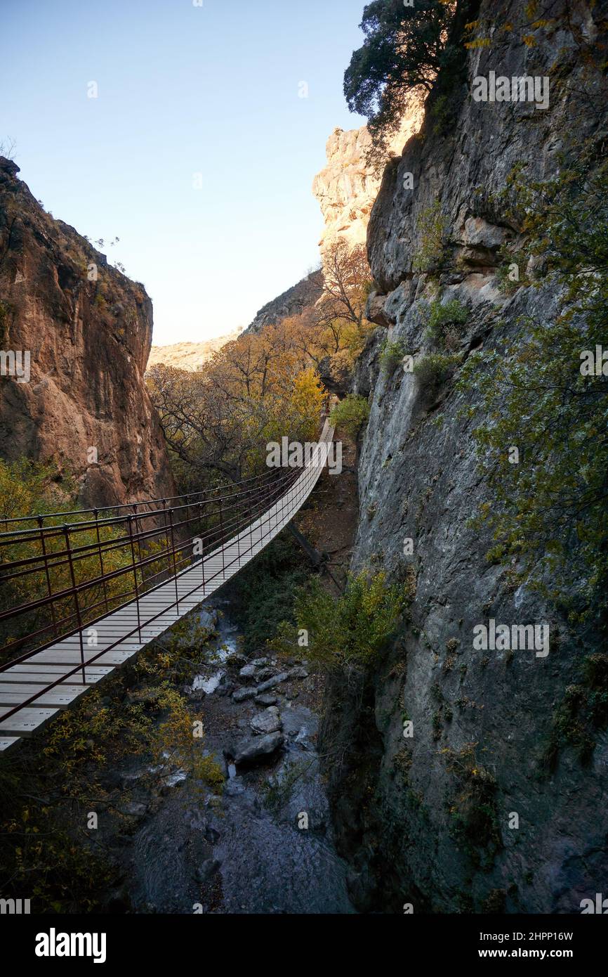 Wooden hanging bridge in between rocky cliffs over the river Stock ...