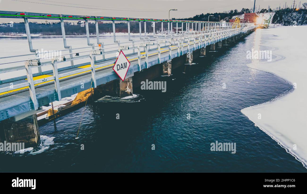 Frozen river with cold walkway at top of the dam Stock Photo - Alamy