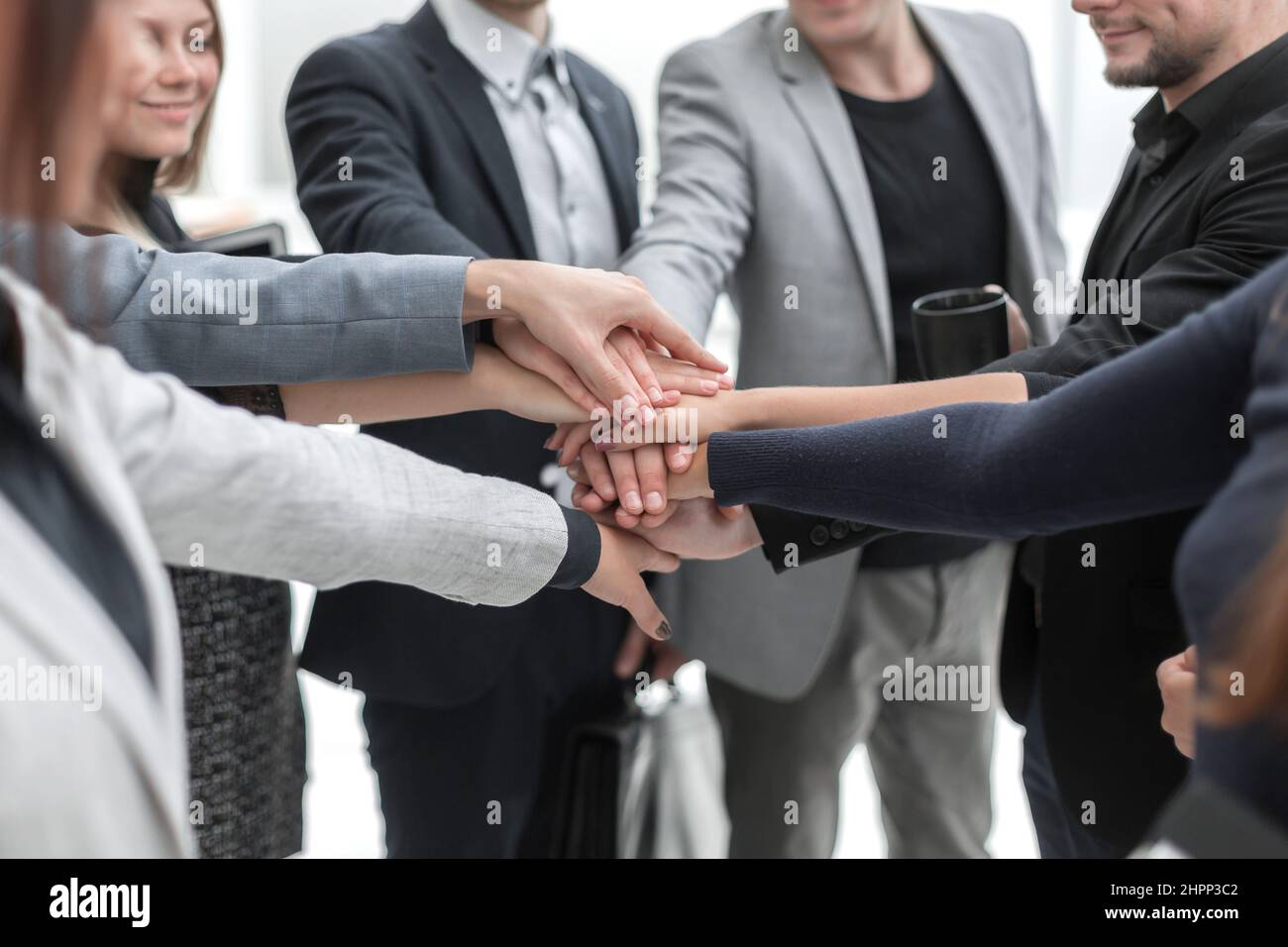 young employees making a stack out of their hands. the concept of ...