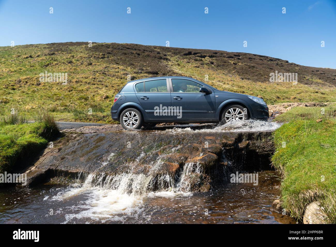 Car driving over a ford on a moorland road in the Yorkshire Dales ...