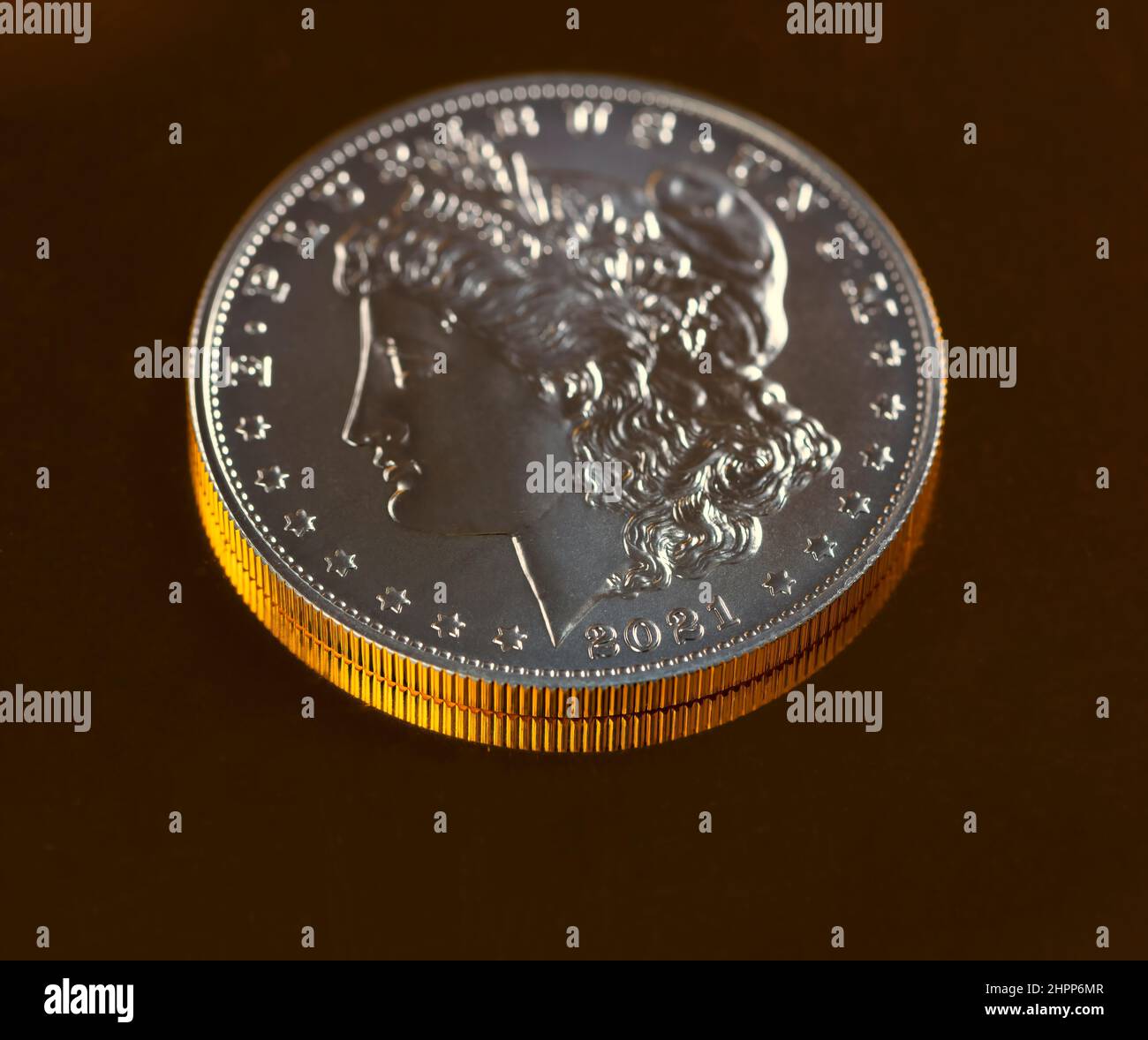 Close up of 2021 Morgan silver dollar on reflecting gold background ...