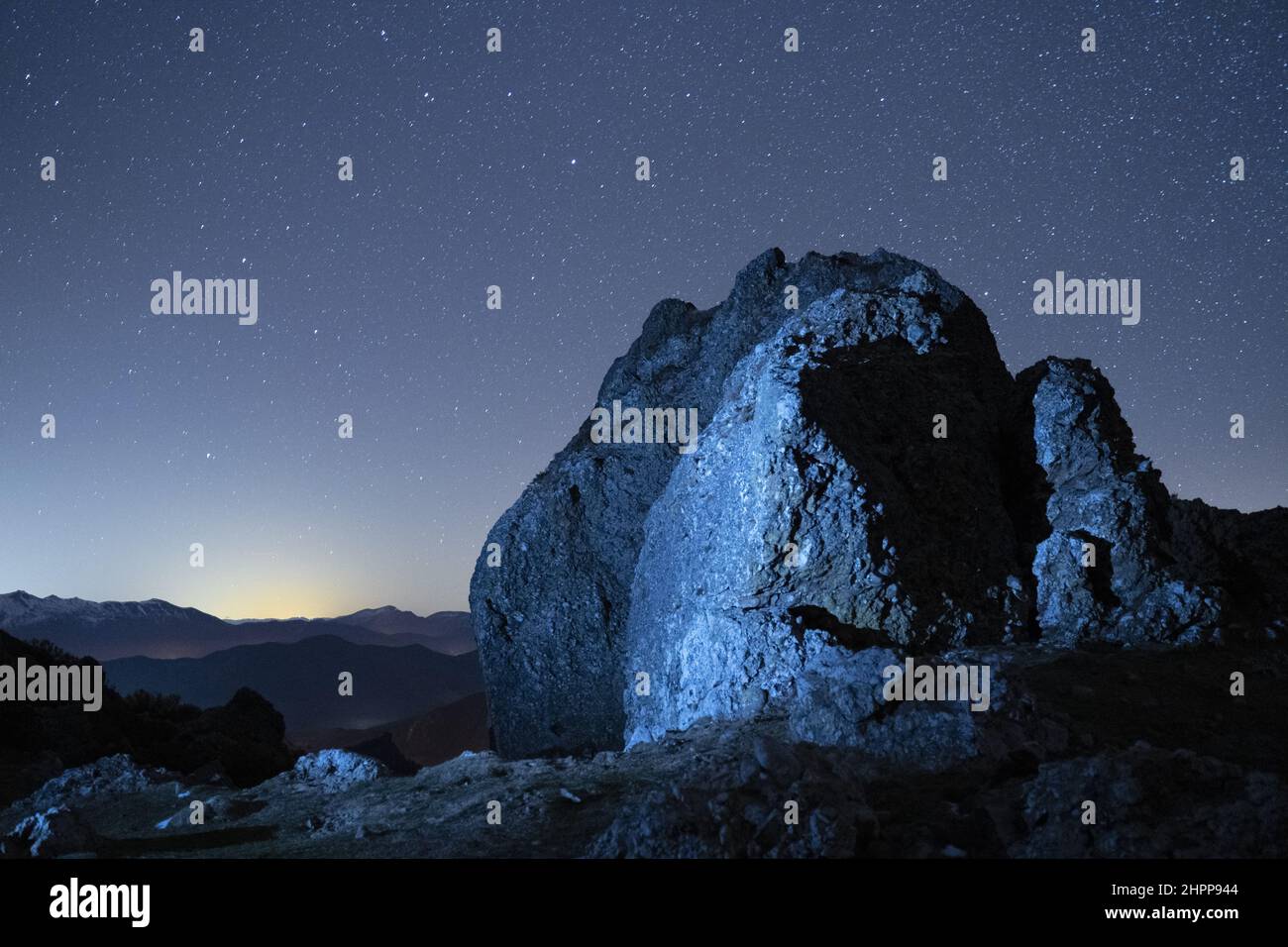 Scenic view of a rock against the mountain under the starry night sky ...