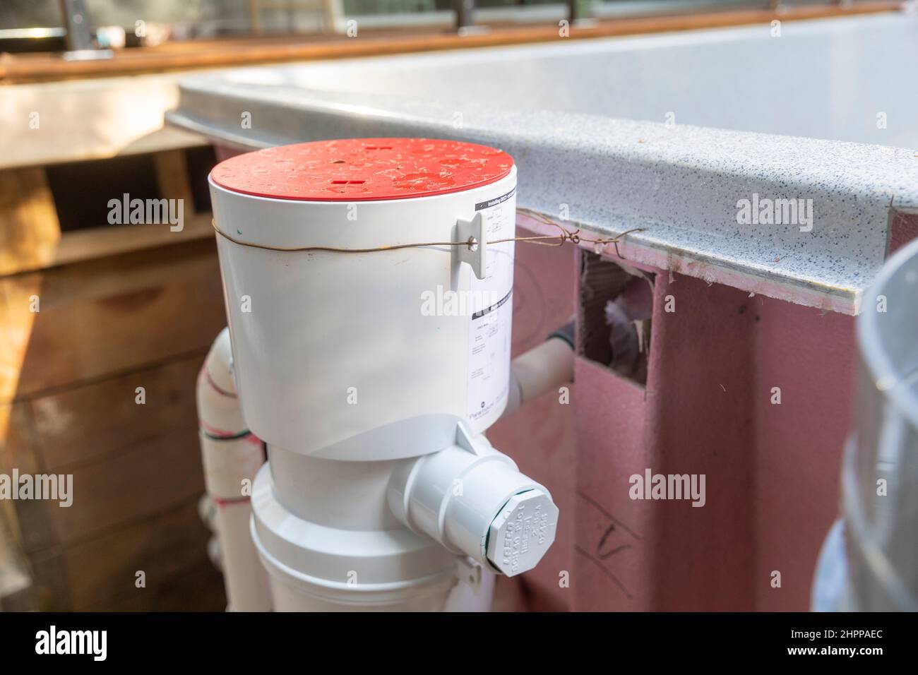 Fibreglass swimming pool in position with plastic plumbing pipework and ...