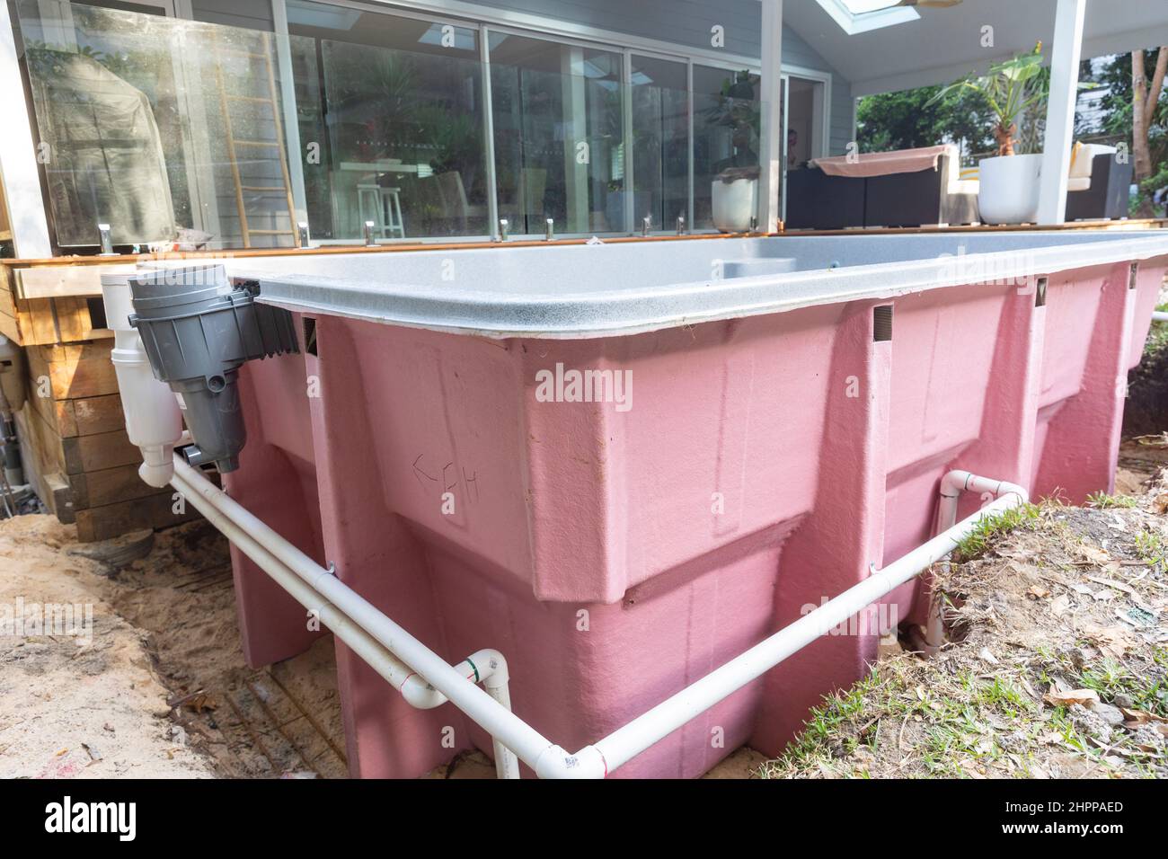 Fibreglass swimming pool in position with plastic plumbing pipework and ...
