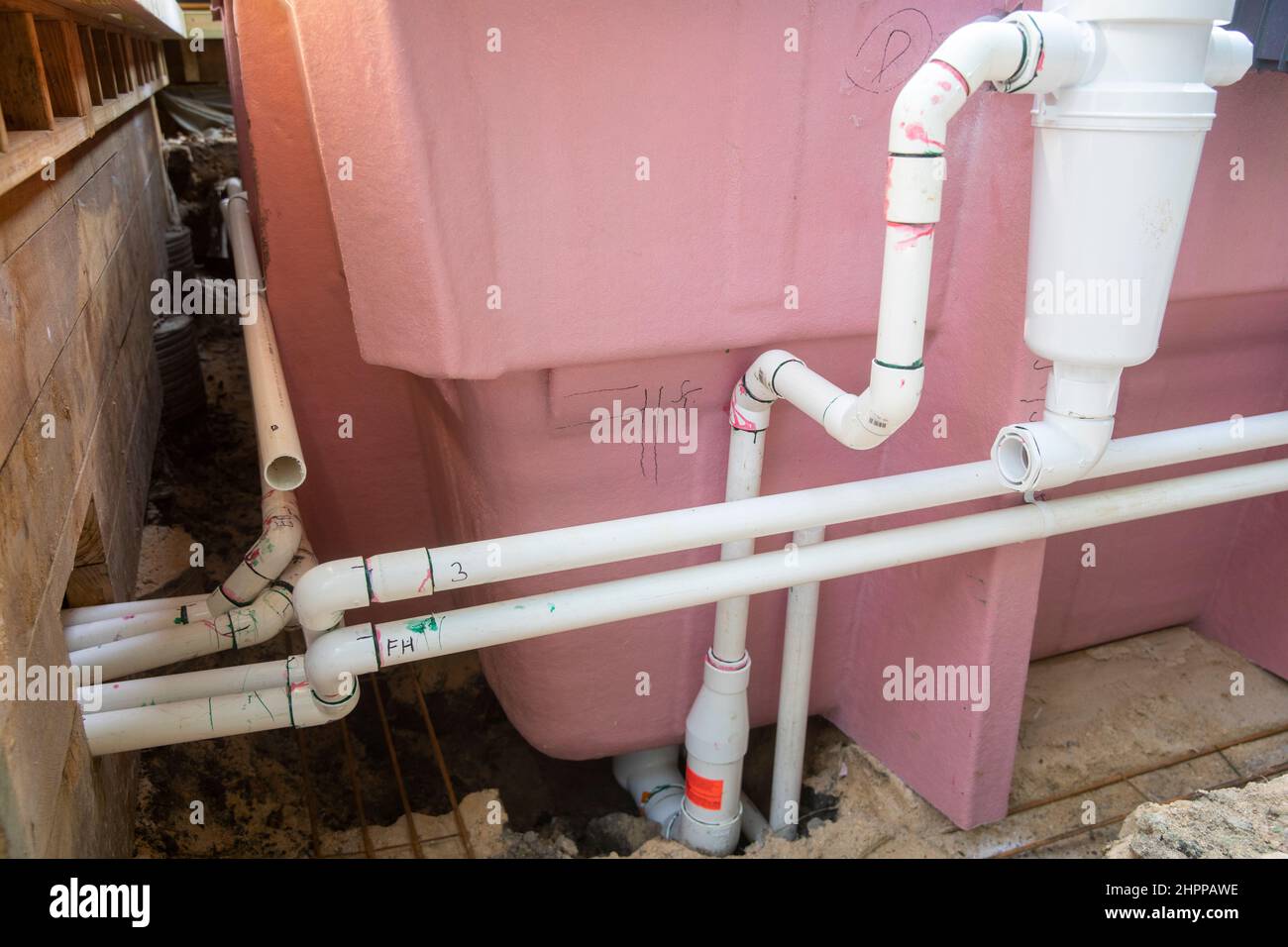 Fibreglass swimming pool in position with plastic plumbing pipework and ...