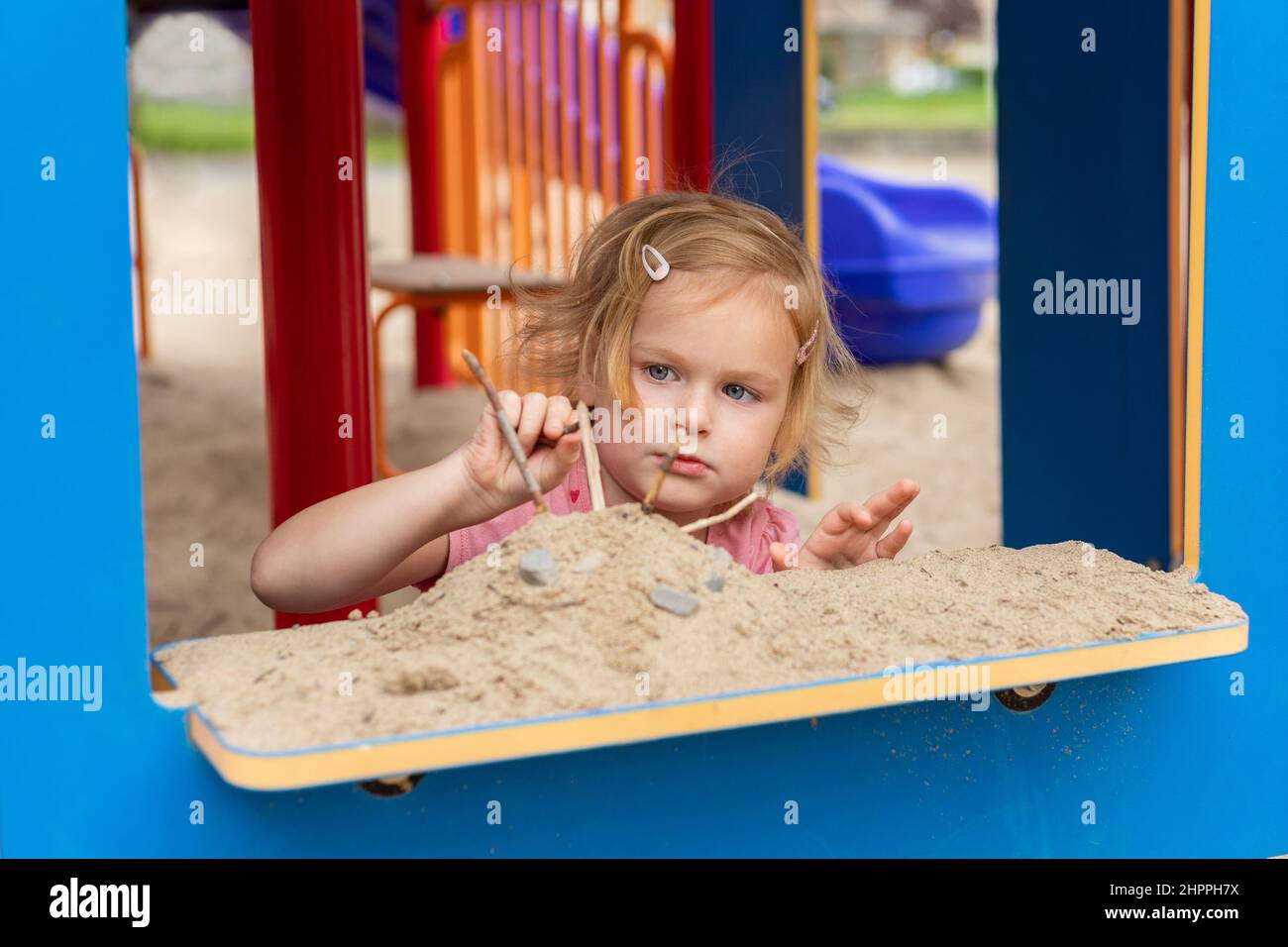 Little child playing with sand at playground sandbox. Kid building with ...