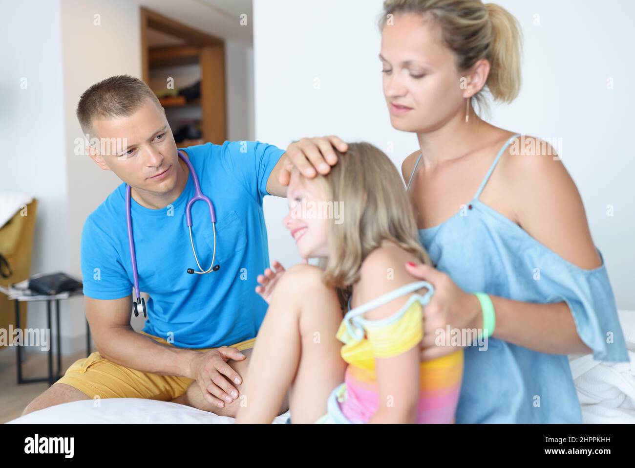 Doctor conducts medical examination of child in hotel rooms at resort ...