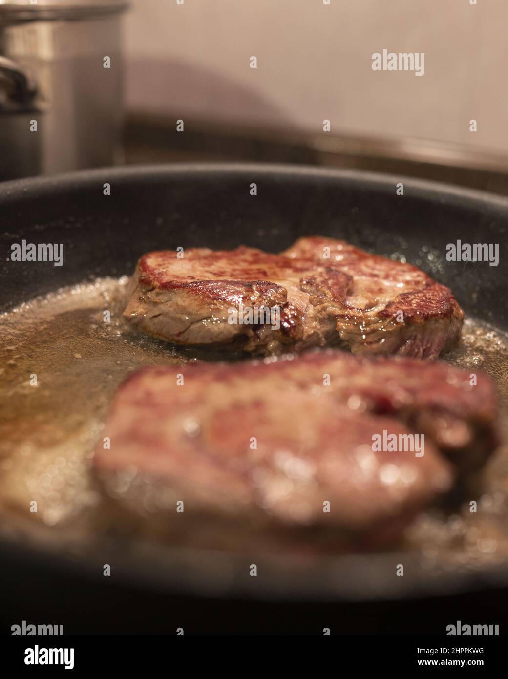 Closeup shot of the process of meat being cooked in a pan Stock Photo ...