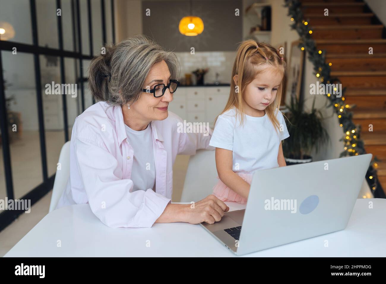 Child and granny looking at the camera with laptop Stock Photo - Alamy