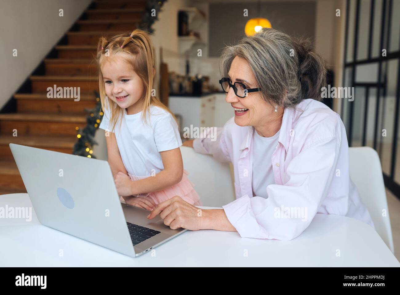 Child and granny looking at the camera with laptop Stock Photo - Alamy