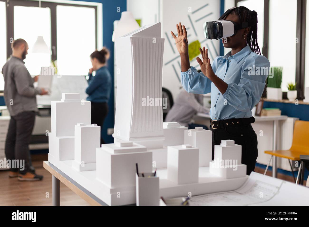 Architect using vr headest to look at white foam scale model of real ...