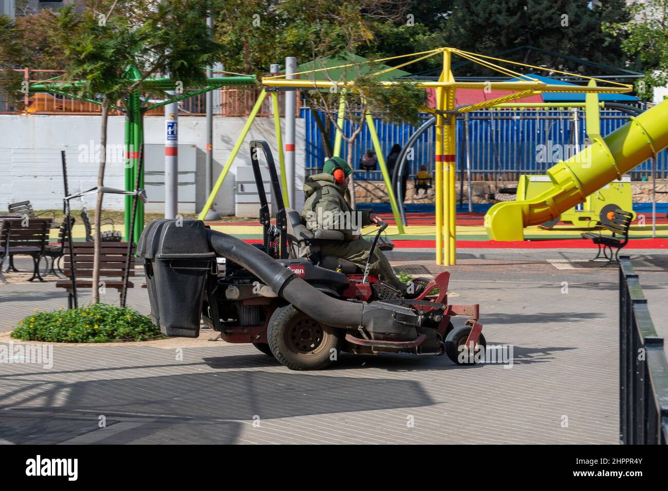 Netanya, Israel - February 8, 2022: A cleaner on a tractor with a lawn ...