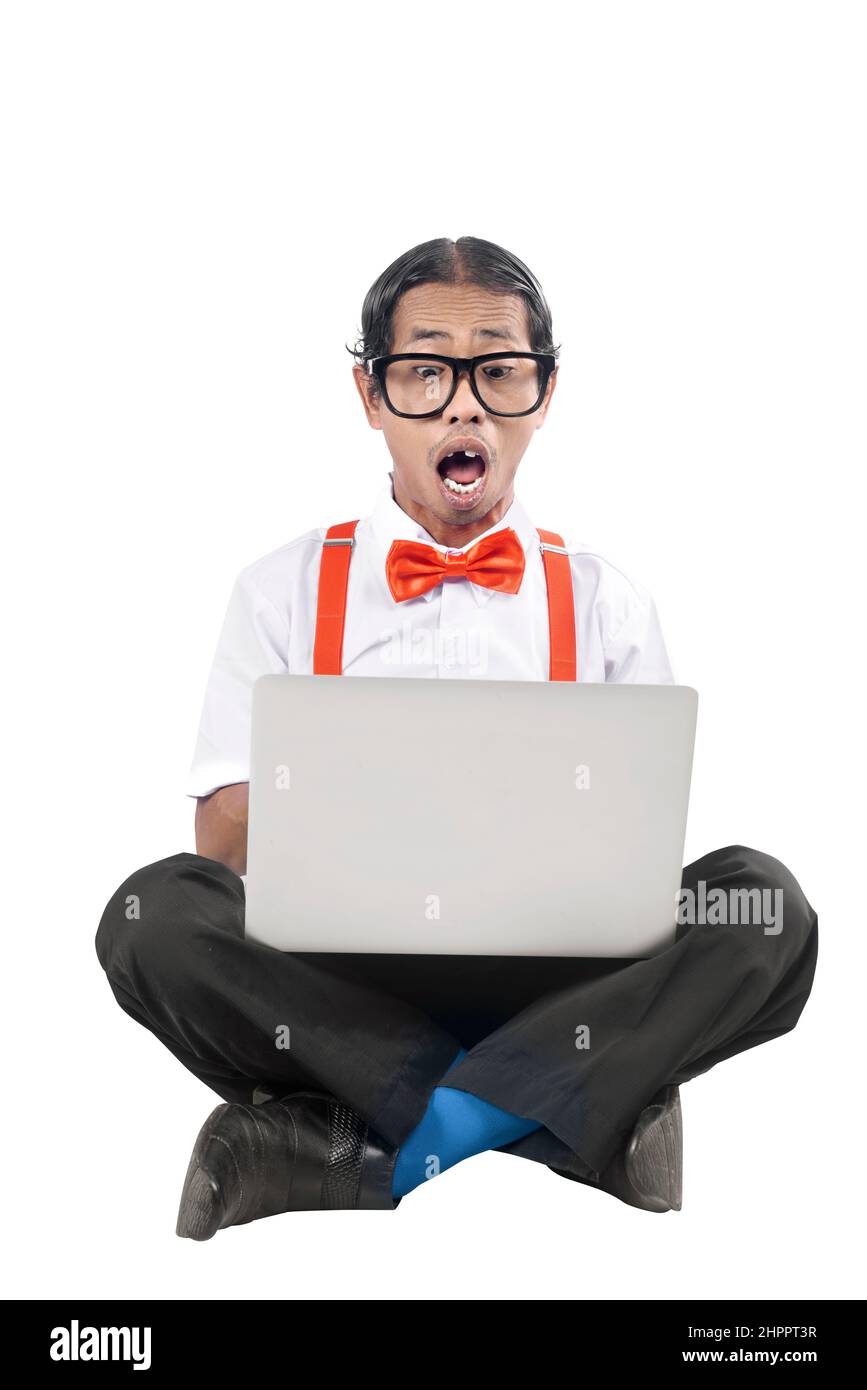 Asian nerd with ugly face sitting while using laptop isolated over ...