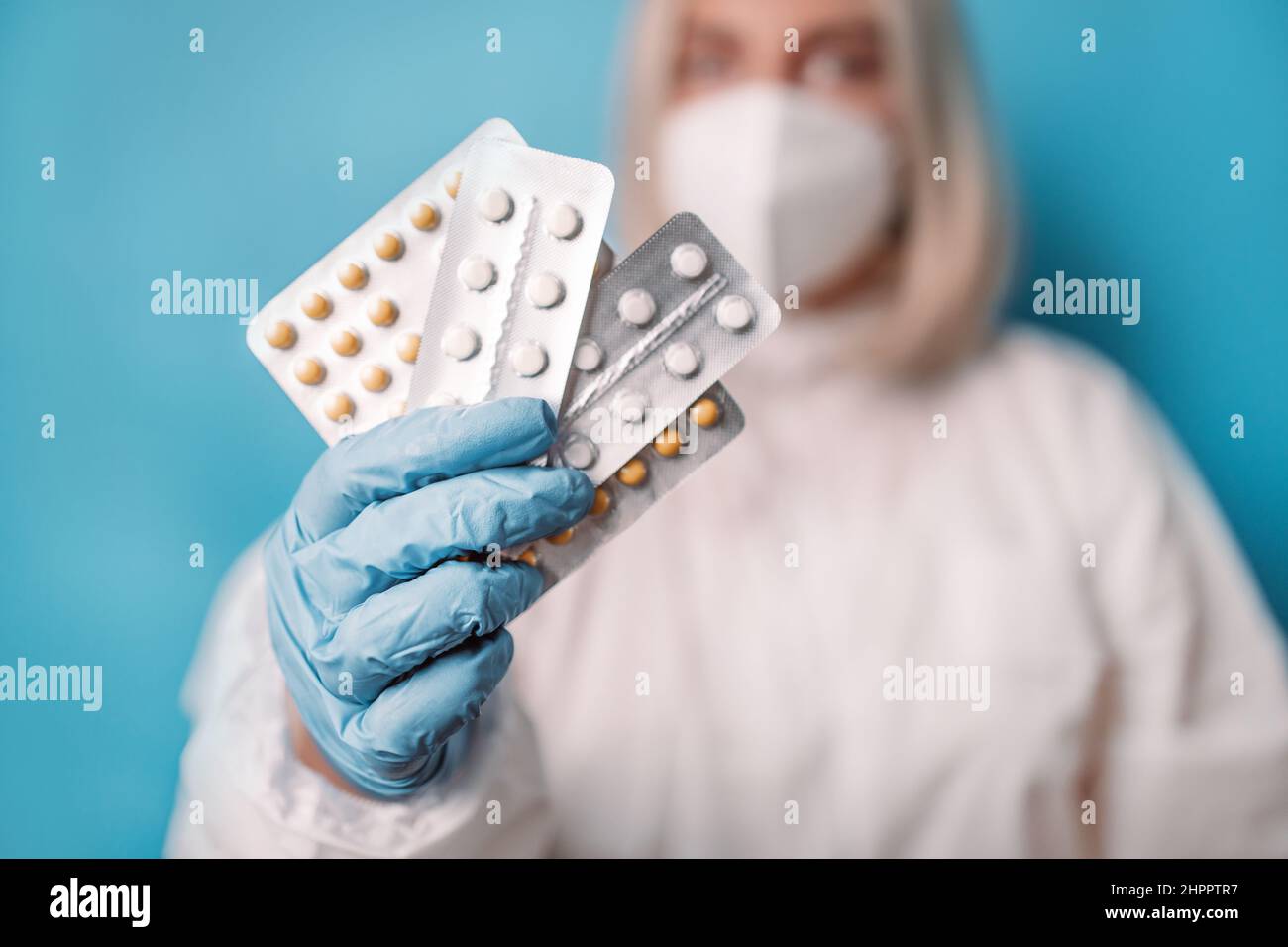 Close up of female doctor looking at camera wearing face mask holding ...
