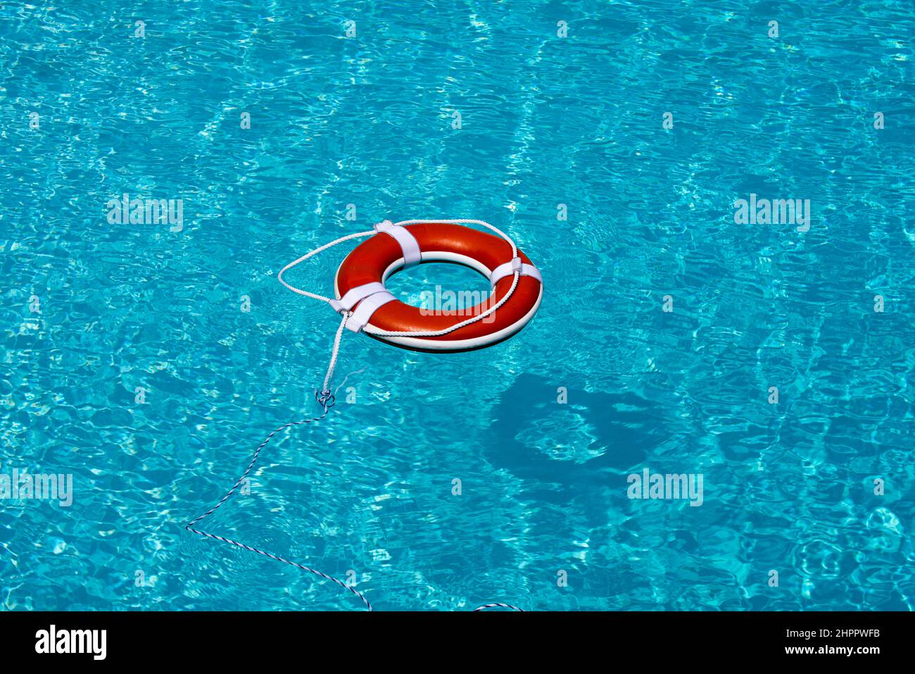 Life buoy in blue swimming pool. Lifebuoy pool ring float on blue water ...