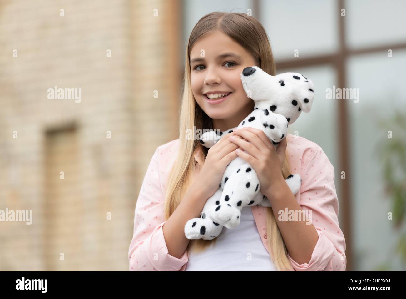 Happy girl child cuddling soft toy outdoors, childhood Stock Photo - Alamy