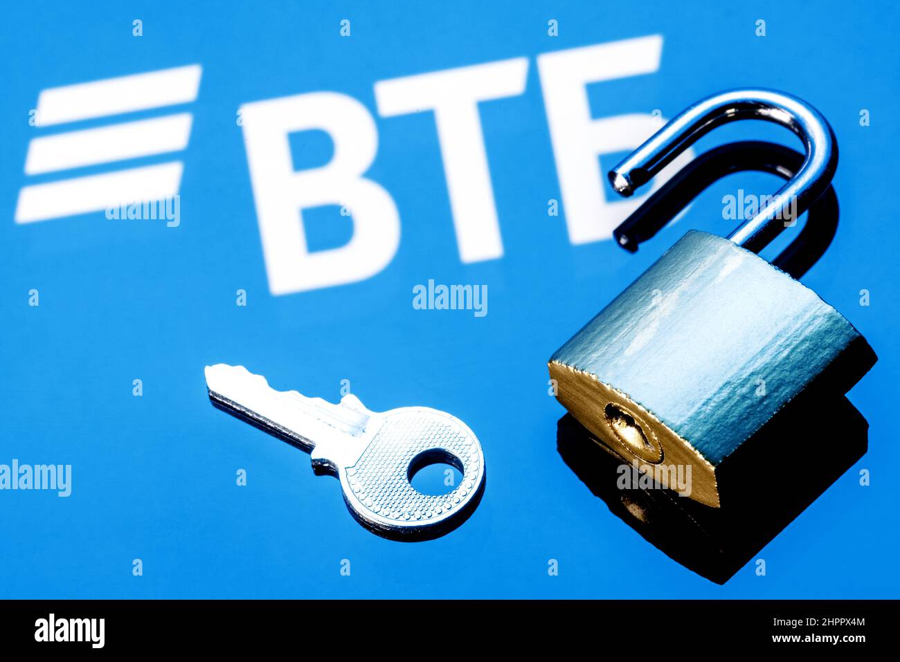 An open security lock and key on background of VTB bank logo in mirror ...
