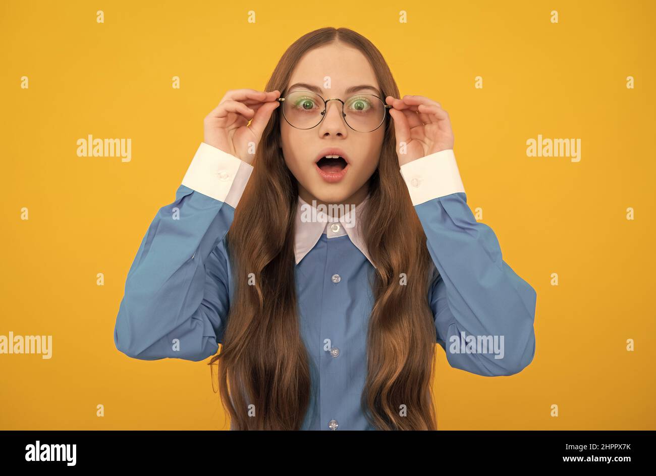 Shocked school aged girl child in spectacles with amazed look yellow ...