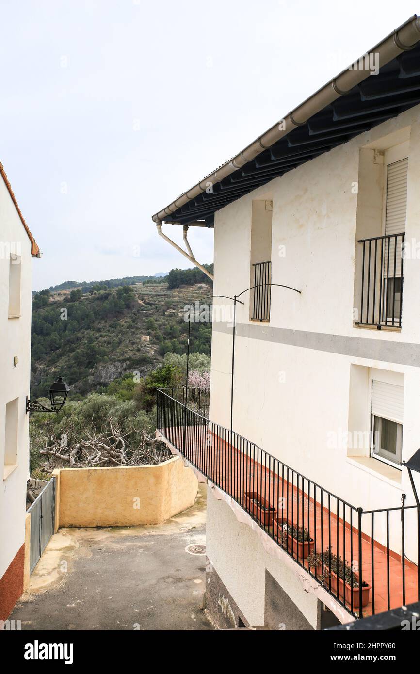 Whitewashed facades and narrow street in Abdet village, Alicante, Spain ...