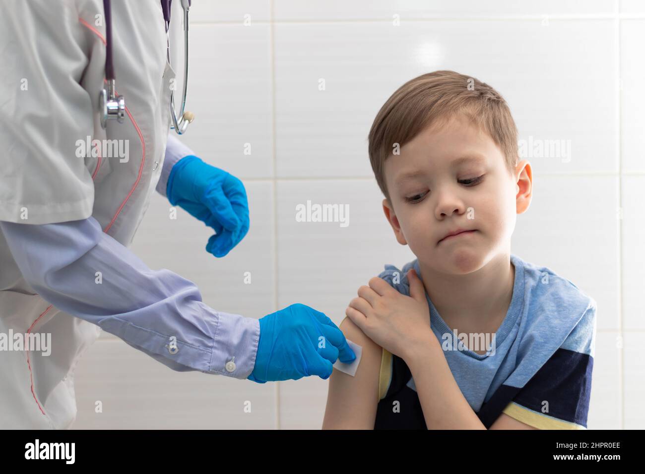 A doctor in a white medical coat and rubber gloves with a phonendoscope ...