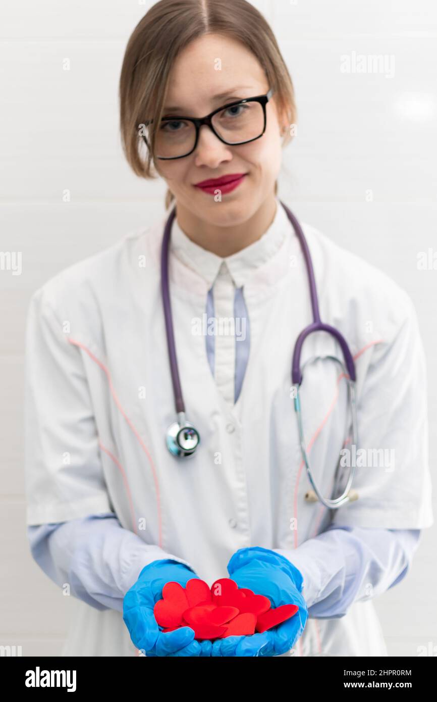 Young pretty woman doctor in a white medical coat and rubber gloves ...