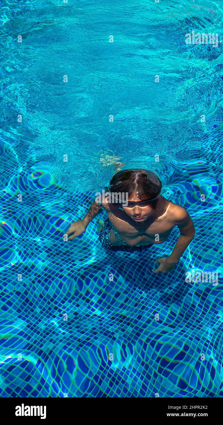 Portrait of a boy in the outdoor swimming pool. Teenager in the ...