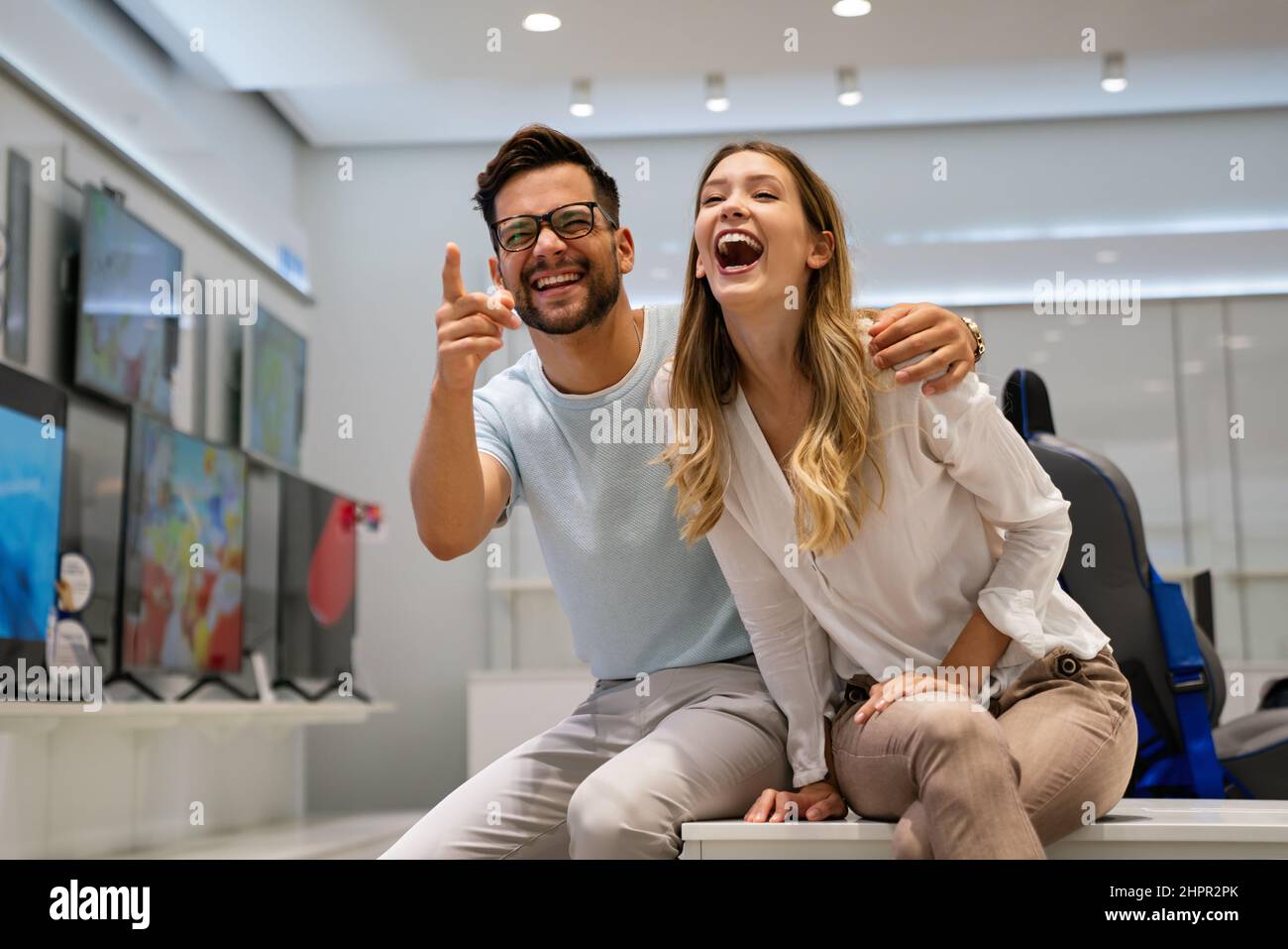 Portrait of happy smiling people having fun in a tech store. Technology ...
