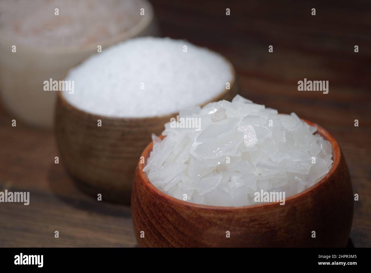 Different natural types of salt on a wooden background. Salt crystals ...