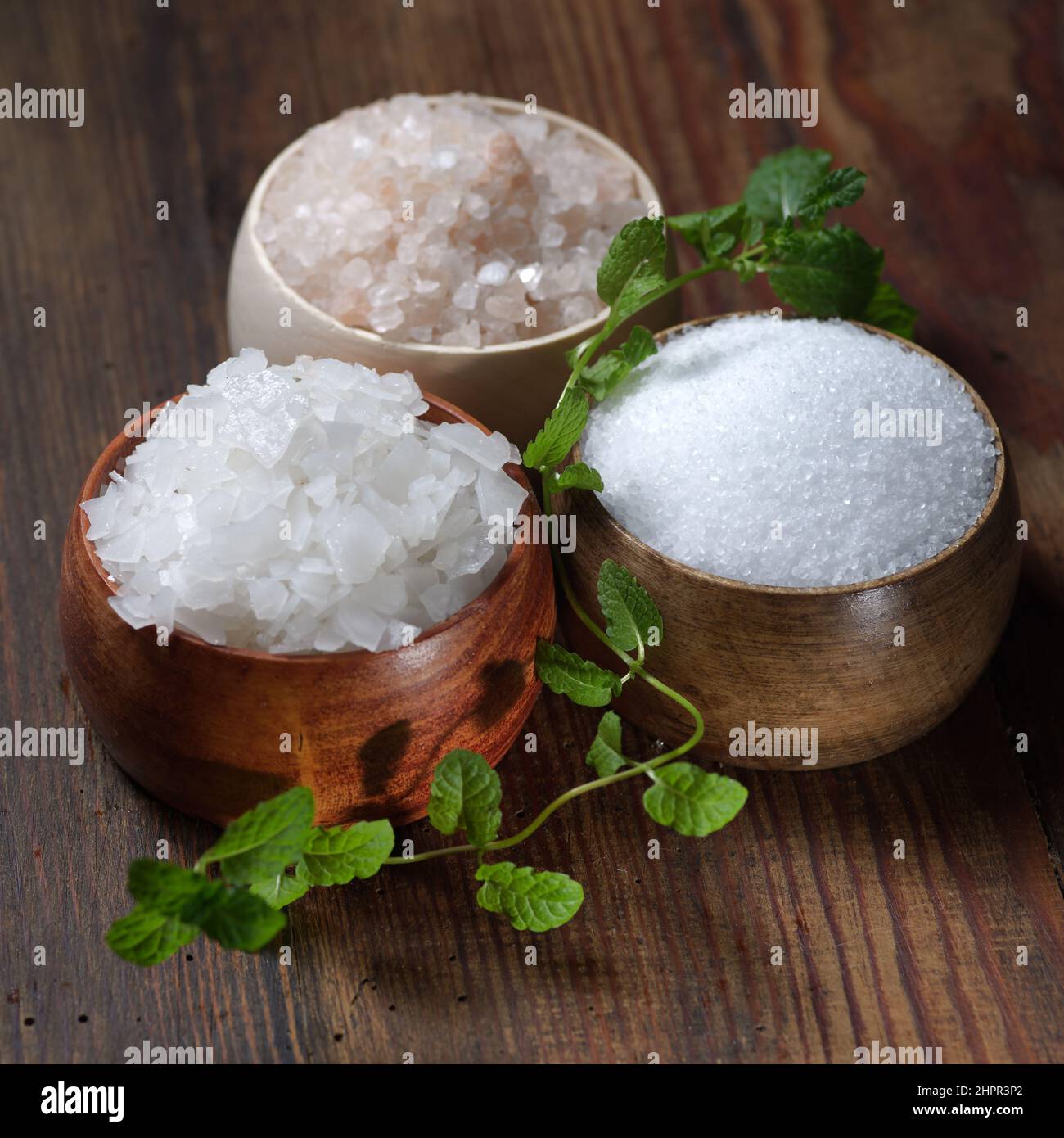 Different natural types of salt on a wooden background. Salt crystals ...