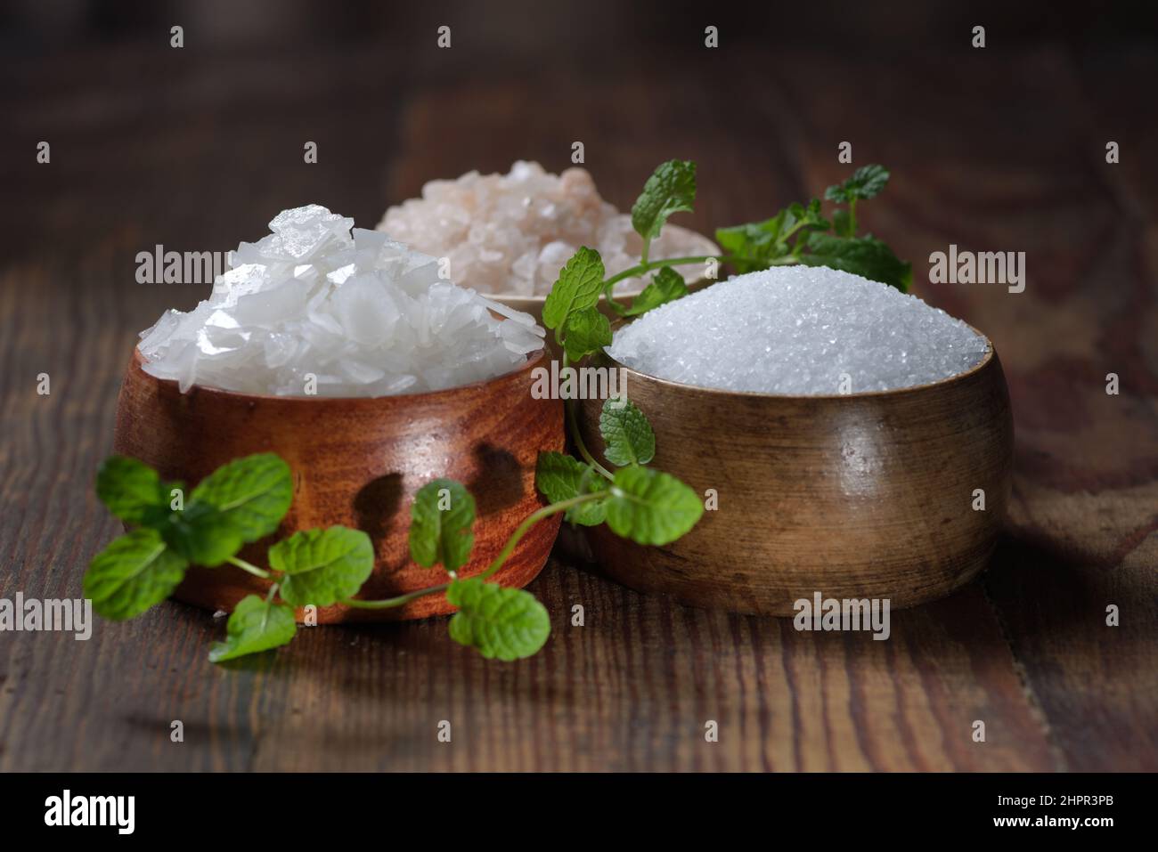 Different natural types of salt on a wooden background. Salt crystals ...
