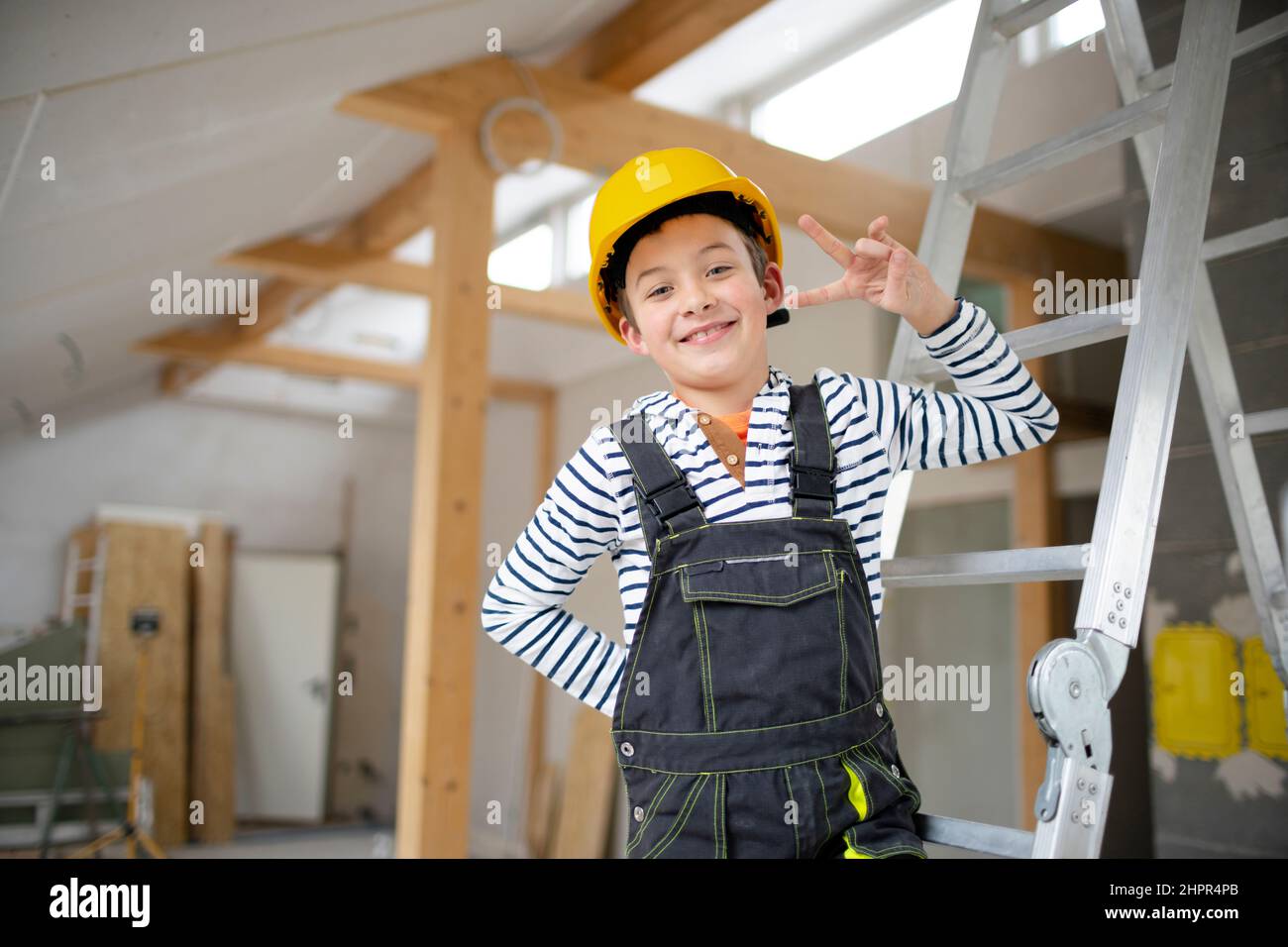 cool young boy with yellow safety helmet posing and having fun on ...