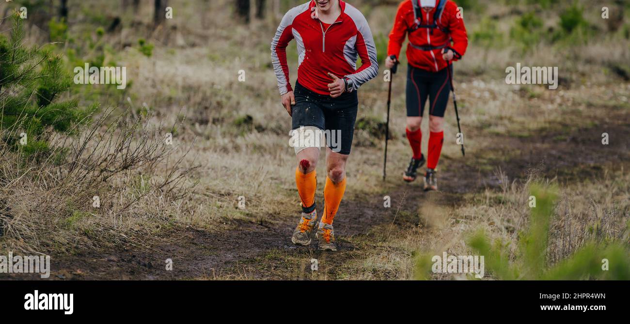 two male runners run muddy trail race in forest Stock Photo - Alamy