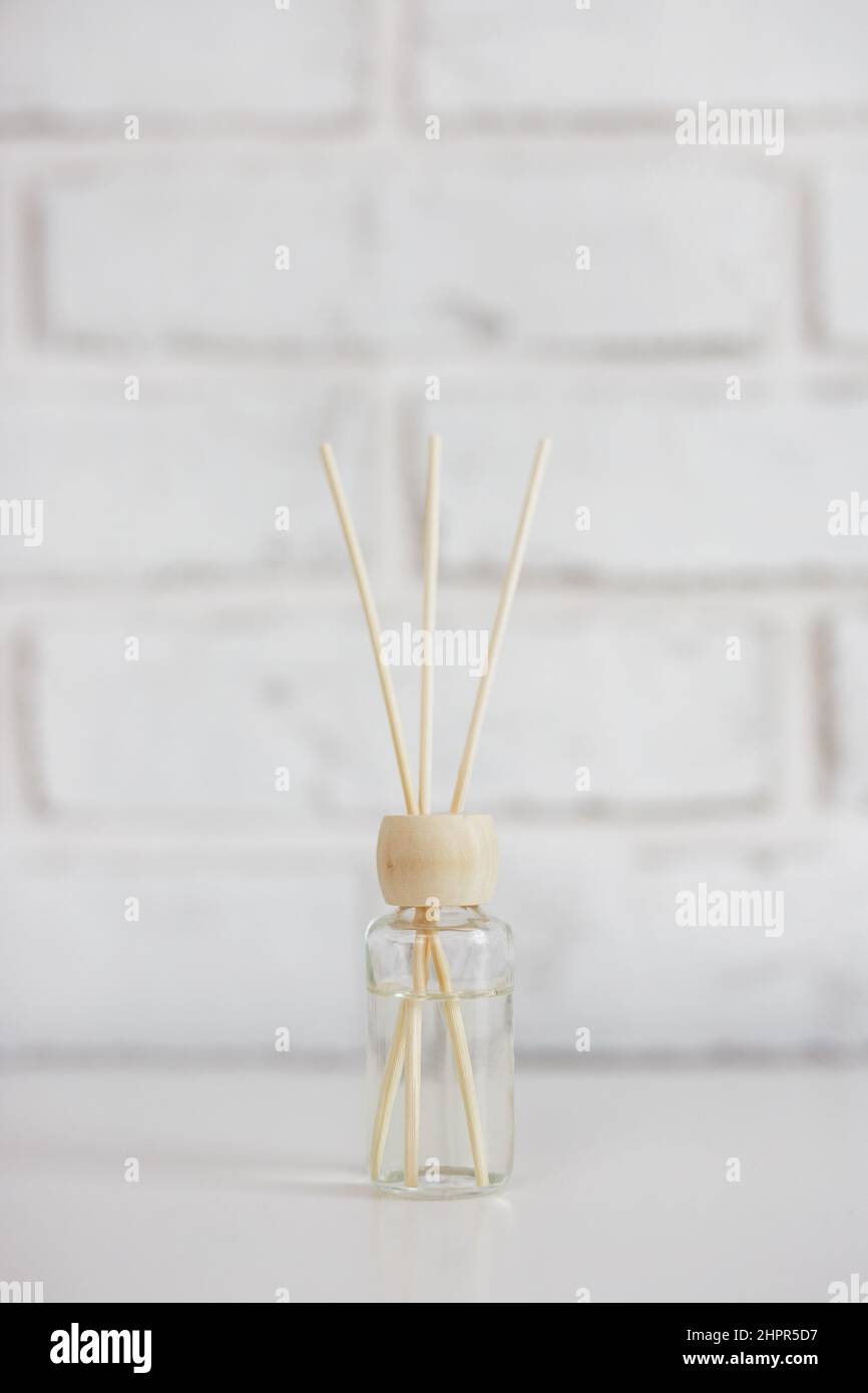 Home aroma fragrance diffuser with bamboo sticks over white brick wall ...