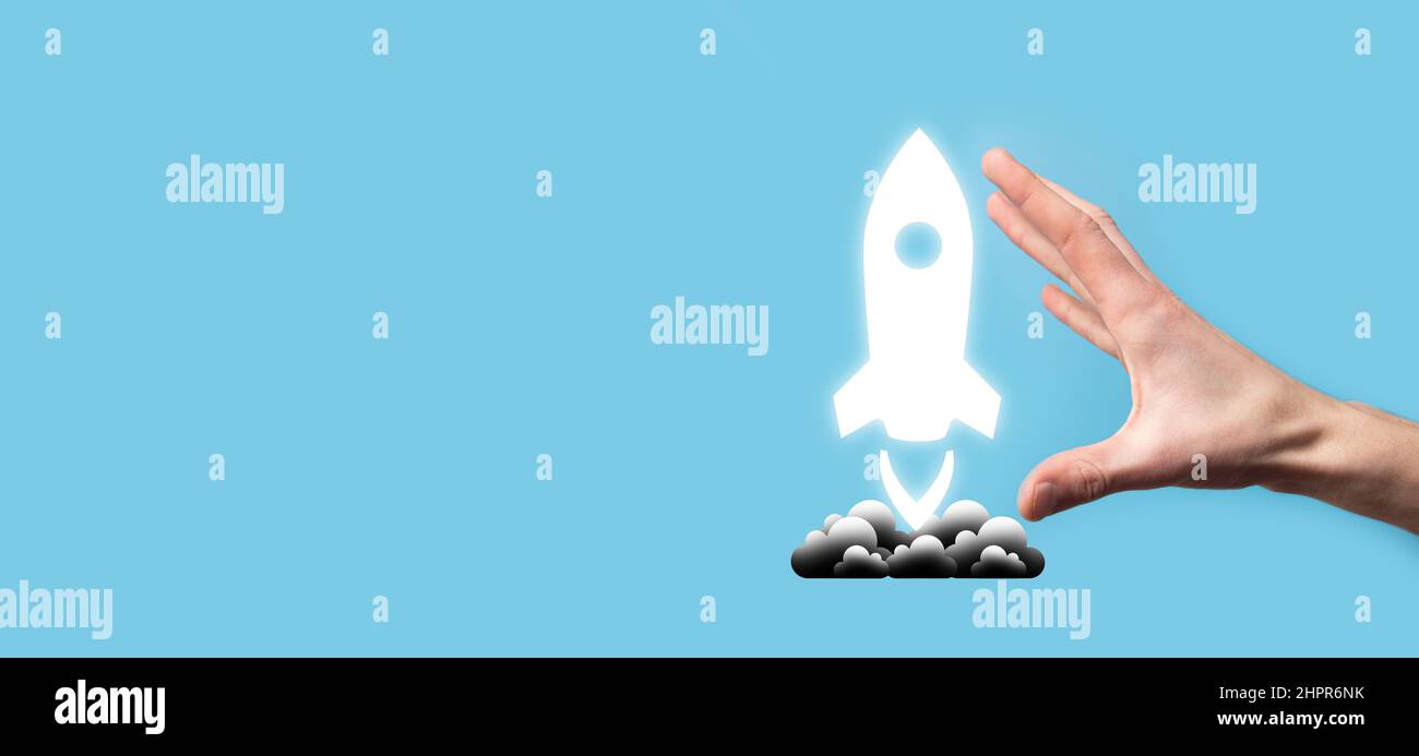 Male hand holding rocket icon that takes off, launch on blue background ...