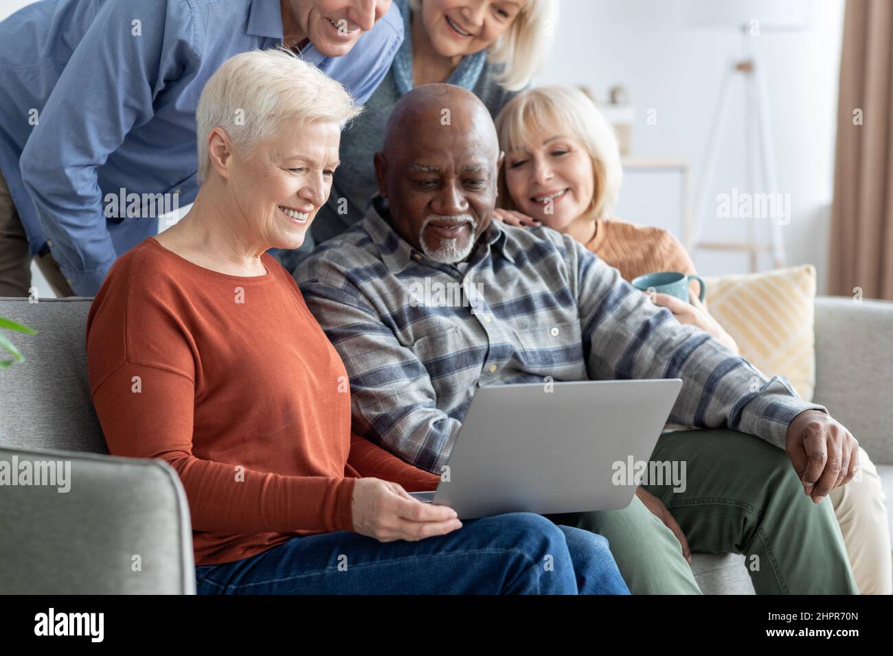 Cheerful multiracial senior people using computer together Stock Photo ...