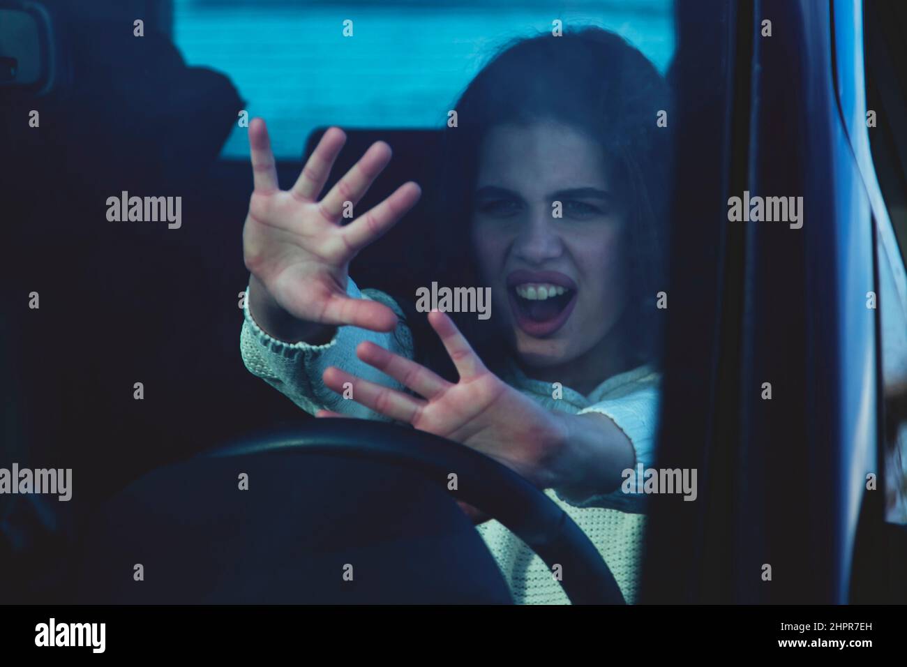 Stressed and confused woman panics in a dangerous situation on the road ...